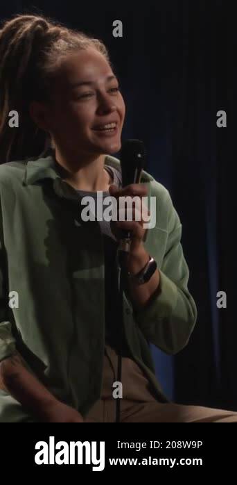 Vertical shot of Caucasian female standup comedian with dreadlocks ...