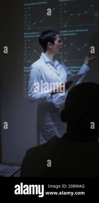Vertical shot of female scientist in lab coat explaining neuroscience ...