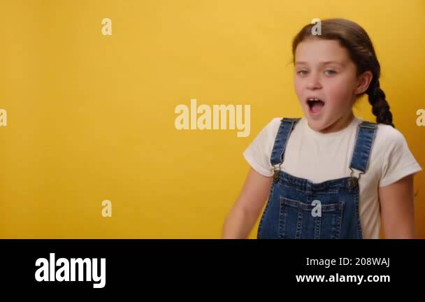 Portrait of shocked preteen girl child point thumb finger aside on copy ...