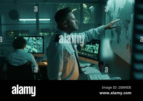 Medium shot of mature Caucasian male officer standing in command center ...