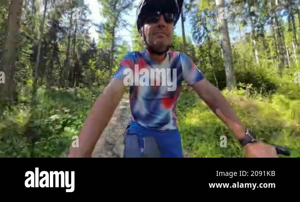 Cyclist riding through a forest trail, transitioning from rider focus ...
