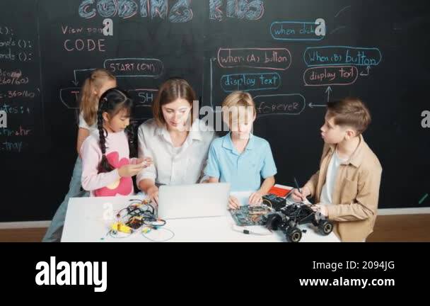 Diverse student writing engineering code while boy fixing mother board ...