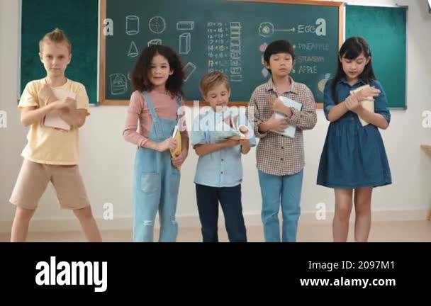 Multicultural elementary student in casual cloth looking at camera ...