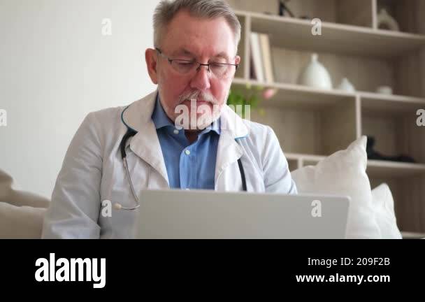 Senior man doctor working with laptop computer. Professional senior ...