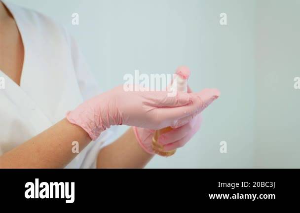 Woman holding liquid spray antiseptic during skincare procedure. Female ...