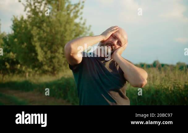 Bald male performing creative head dance with closed eyes and peaceful ...