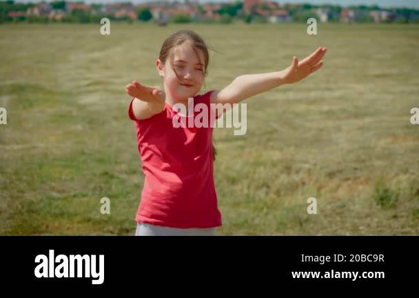 Teenage girl practicing gymnastics in open space, making athletic arm ...