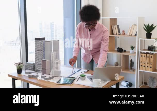 African American female architect works on modern city project using ...