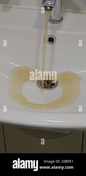 Dirty water flows from the tap into the sink. Contamination of drinking ...