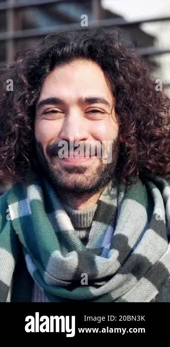 Portrait of young stylish Italian Spanish man with long curly hair ...