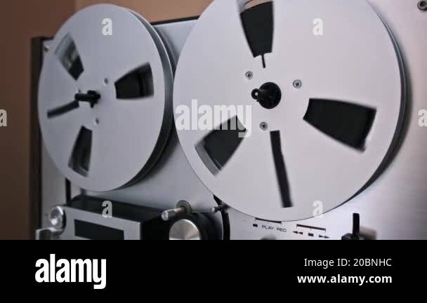 A vintage reel-to-reel tape recorder featuring spinning reels and ...