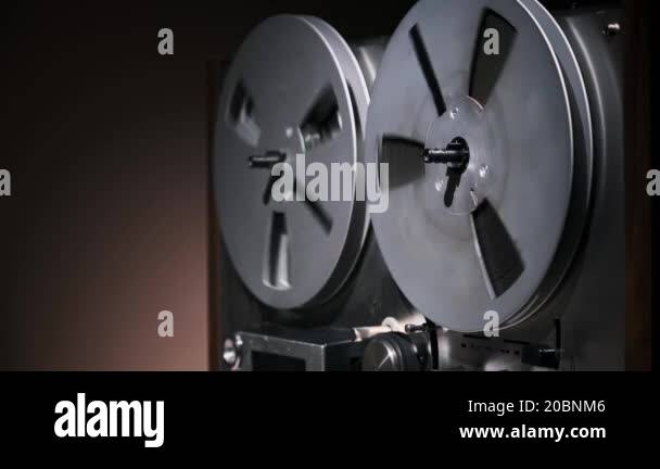 Close-up of a classic reel-to-reel tape recorder with spinning silver ...