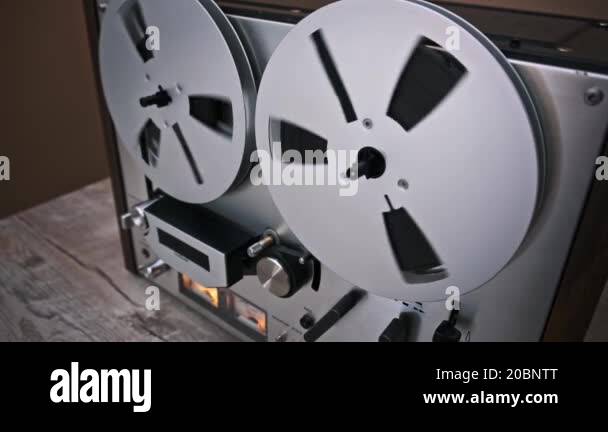 Close-up of a vintage reel-to-reel tape recorder with rotating spools ...