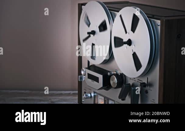Close-up of a vintage reel-to-reel tape recorder with spinning silver ...