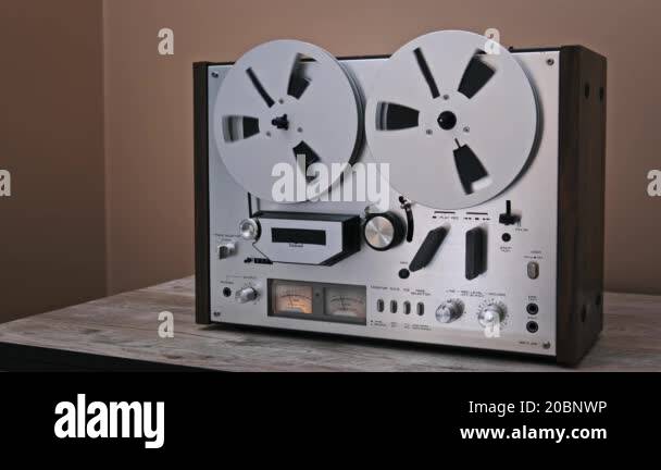Close-up retro reel-to-reel audio recorder with spinning tape reels ...