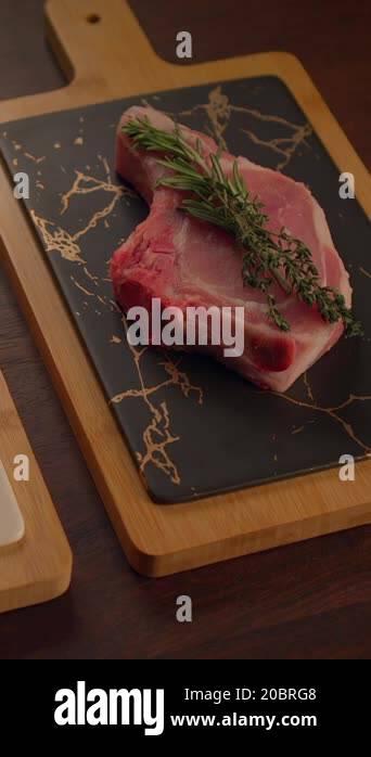 A beautifully marbled pork chop, exquisitely garnished with fresh thyme ...