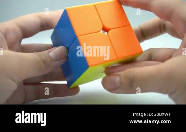 A hand rotating while looking at a 2x2 Rubik's cube that is not ...