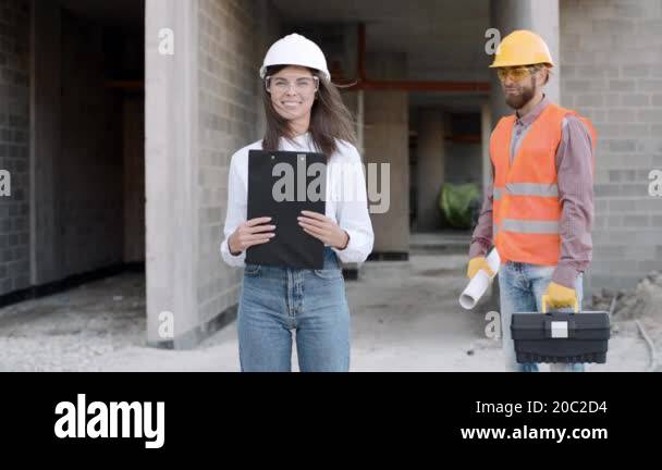 Construction workers collaborate on project plans at a building site ...