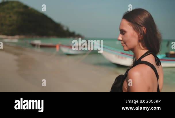A woman stands on the sandy shores of Bottle Beach, Koh Phangan, with ...