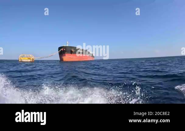 A striking view of a large bulk carrier anchored in the tranquil waters ...