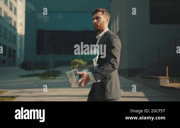 Sad office worker man walking with box of personal stuff lose a job got ...