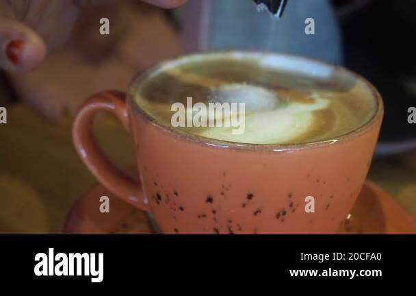 white sugar pouring from a in a paper packet on a coffee cup Stock ...