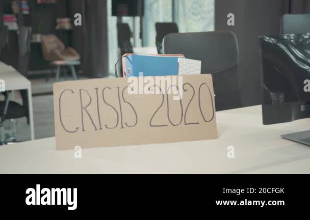 Crisis 2020 carton placard on working table. Unemployed person ...