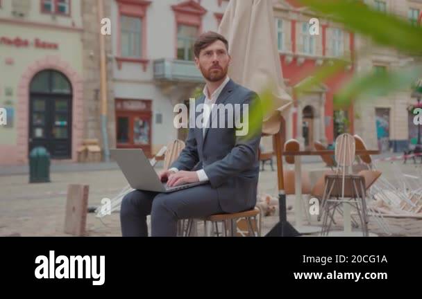 Shocked young business manager in suit with portable laptop sitting on ...