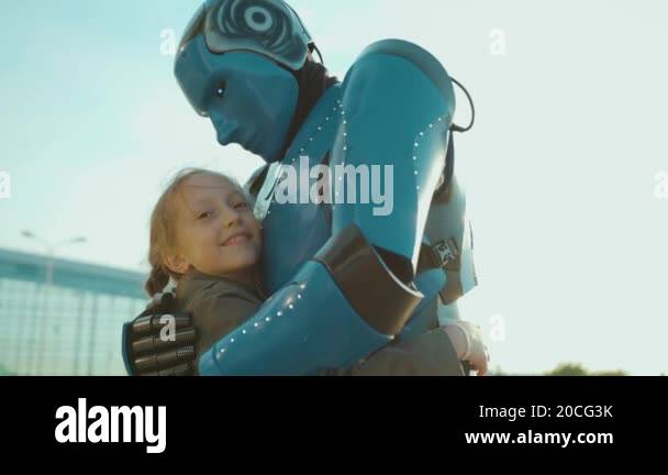 Cute child girl greets her robot friend hugging it at sunlight future ...