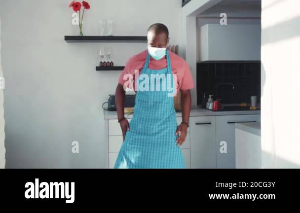 Funny afro-american young man chef in apron face mask dancing ...