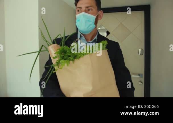 Handsome stylish man coming back home after food shopping entering ...