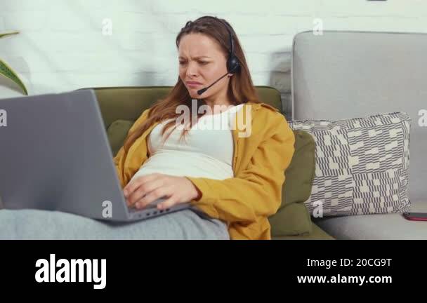 Sad young woman in headphones looking at computer at home have trouble ...