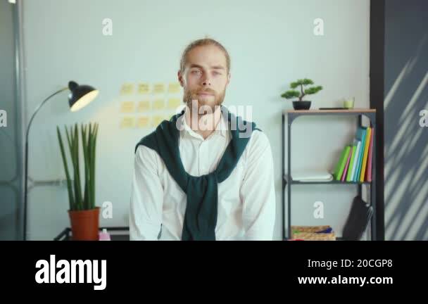 Attractive male boss with beard looking to camera in modern company ...