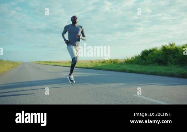 Athletic african american man running jogging on sunny road marathon ...