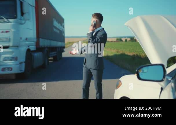 Nervous businessman standing speak on phone near the broken car opened ...