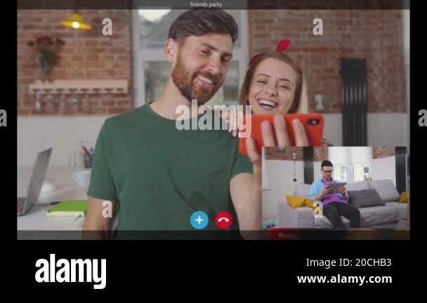 Happy young couple during a video call at the party with friend man ...