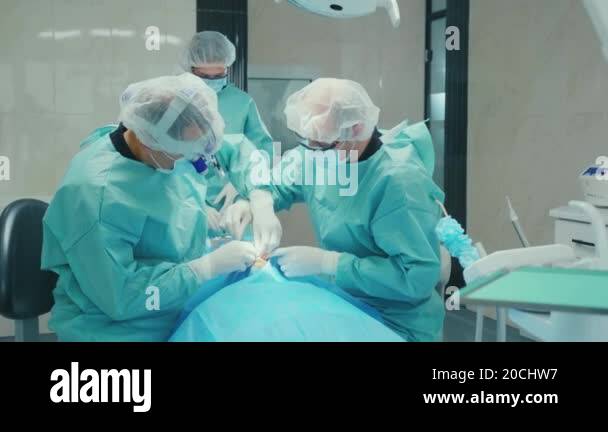 Shot of dentist wear protective suit and gloves working on patient dental surgical operation ...