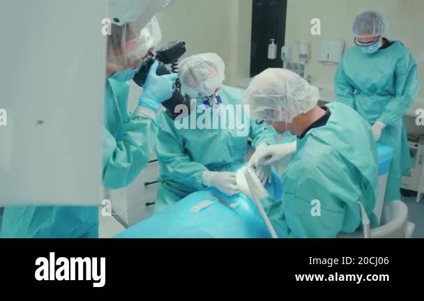 Teamwork dentist wear protective suit and gloves working on patient dental surgical operation ...
