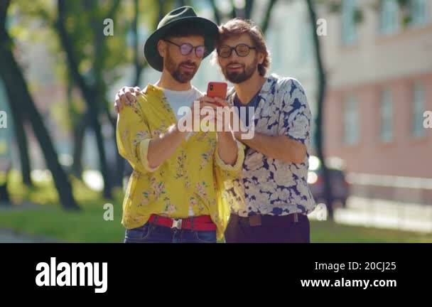 Cute two gay men stand use phone at sunlight feel happy homosexual ...