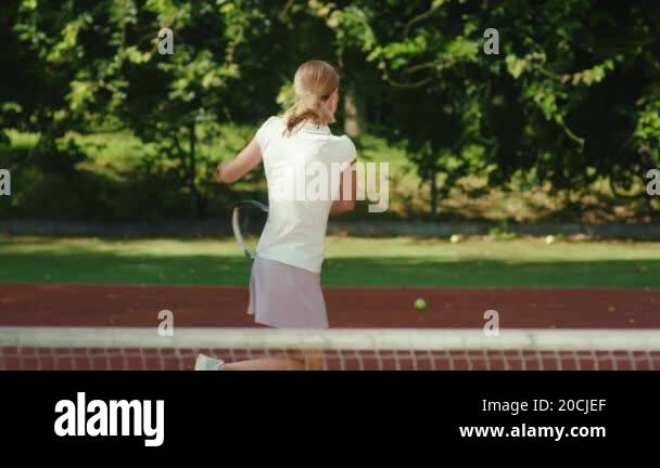 Sad young woman playing tennis outdoor court at sunlight tennis ball ...