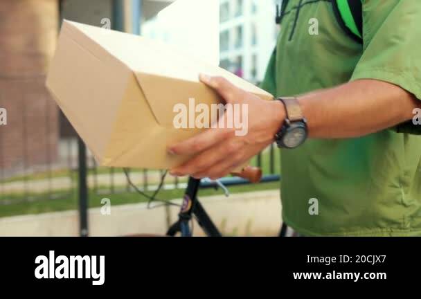 Close up hands courier man give box woman customer outdoor service home package send holding ...