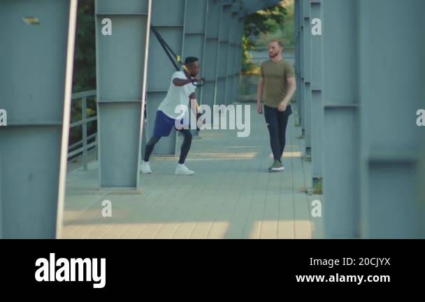 NEW YORK - September 5, 2020: Two men together working out with trx ...