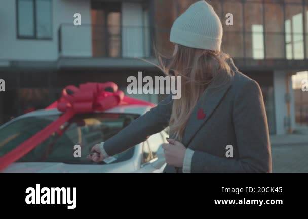 Smiling young woman getting new car look at camera keys gift happy jump look camera automobile ...