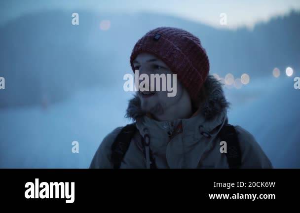 Close up happy young man standing at cold winter steam and looks at ...