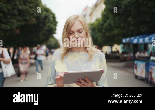 Slow motion business lady uses tablet computer walk attractive ...