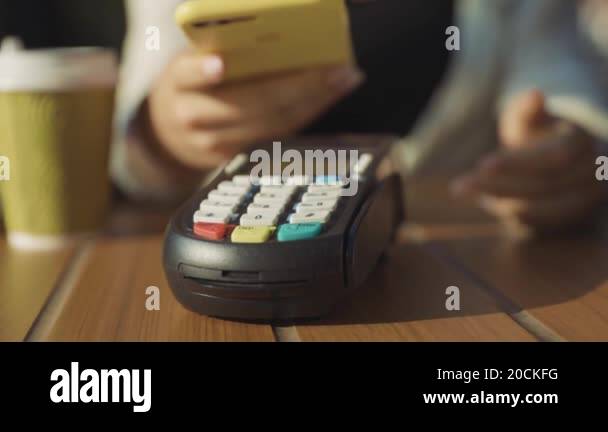 Customer paying for order in the cafe with payment terminal using NFC ...