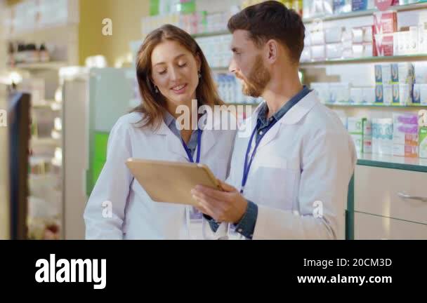 Couple of male and female apothecarists discussing medications sharing ...
