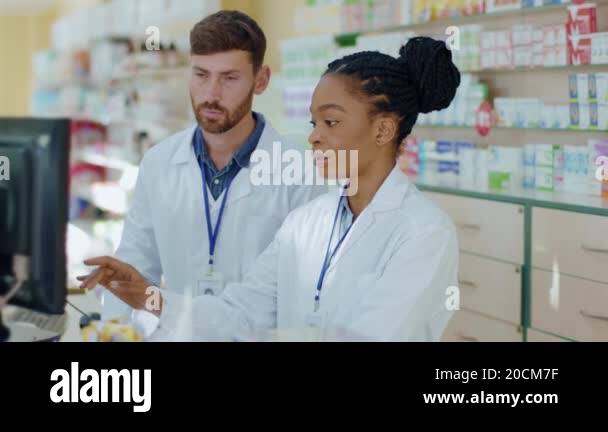 Caucasian and african pharmacists discussing medication for patient ...