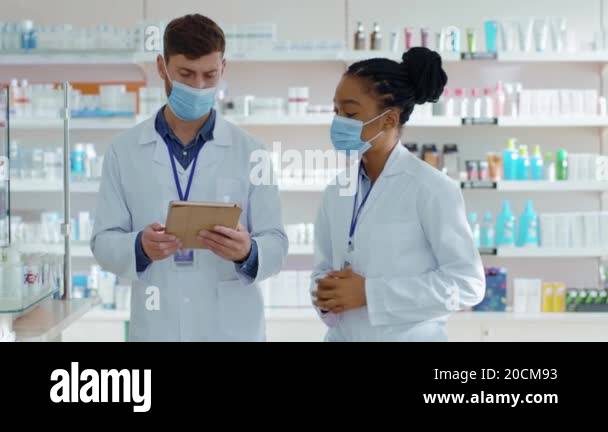African american expert pharmacist consulting caucasian male intern ...