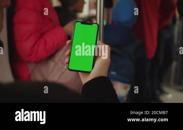 NEW YORK - May 19, 2019: Man young hand uses holding a mobile telephone with a vertical green ...